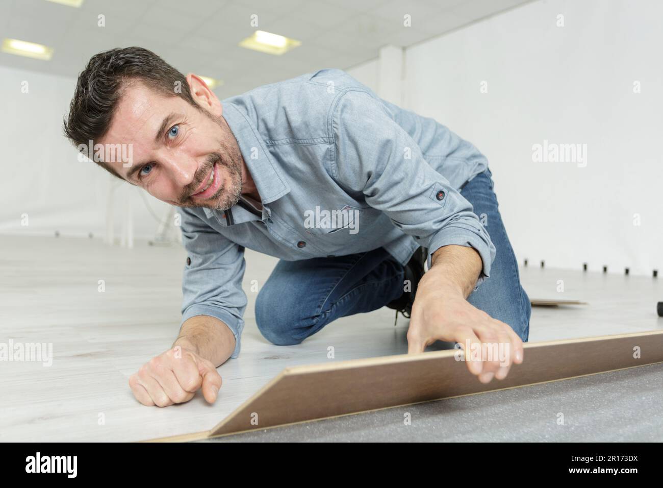 laminate flooring man in sneakers repair Stock Photo - Alamy