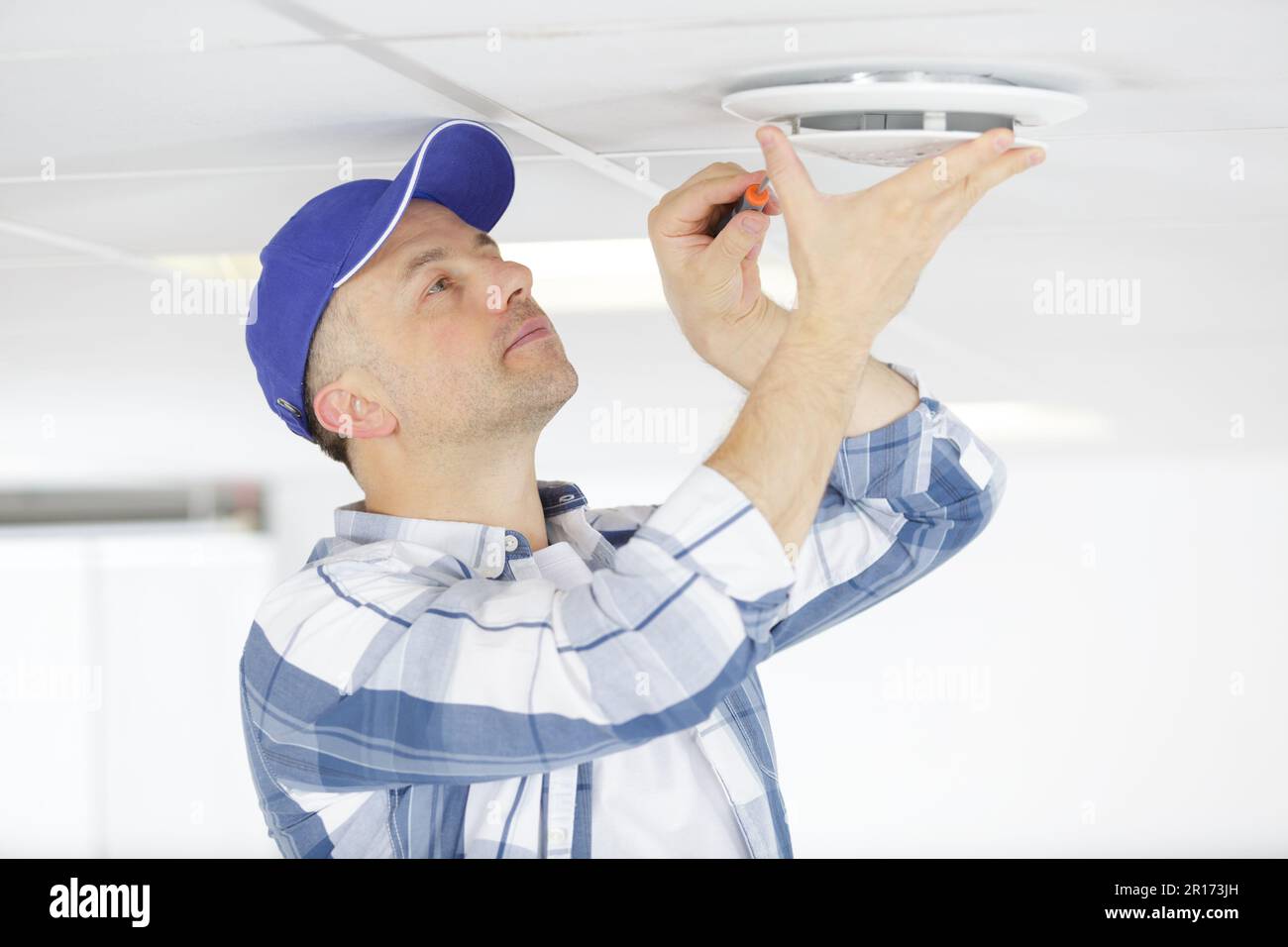 mature man fitting smoke detector Stock Photo - Alamy