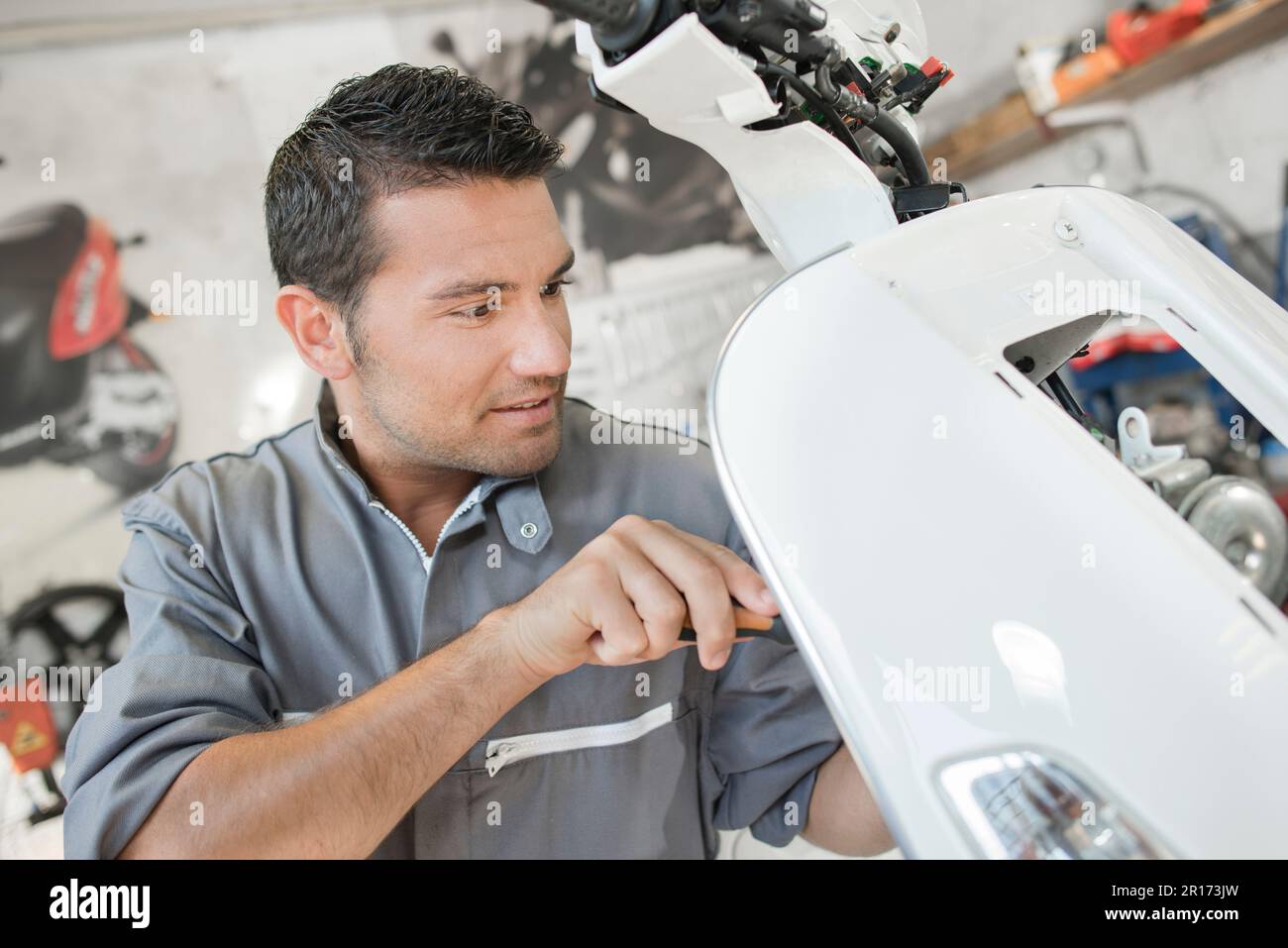 a mechanic is servicing a scooter Stock Photo - Alamy
