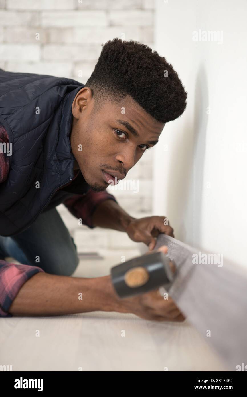 a young man installing flooring Stock Photo - Alamy