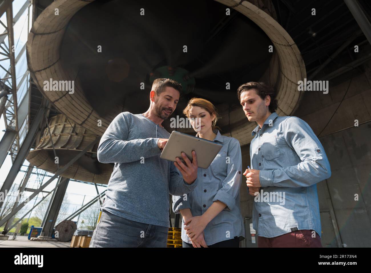 factory worker and apprentice talking under ventilation fan Stock Photo ...