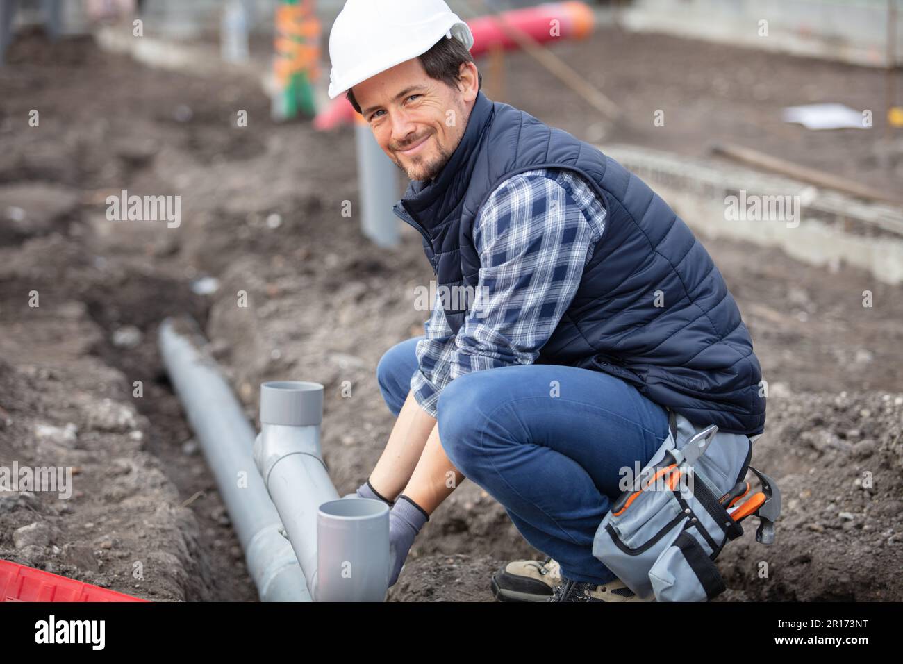 builder installing waste pipes outdoors Stock Photo - Alamy