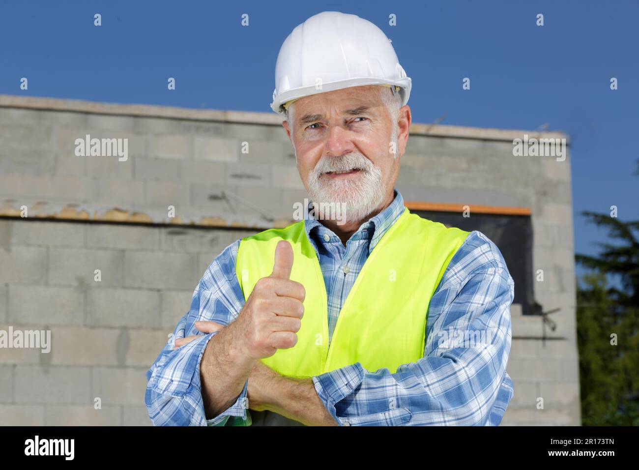 senior workman making thumbs-up gesture on building site Stock Photo ...