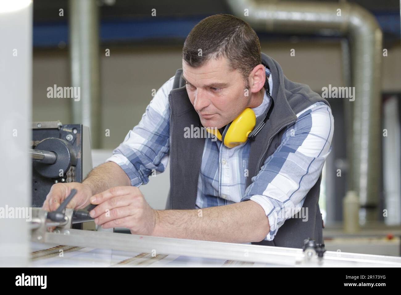 worker in factory on work bench and machine Stock Photo - Alamy