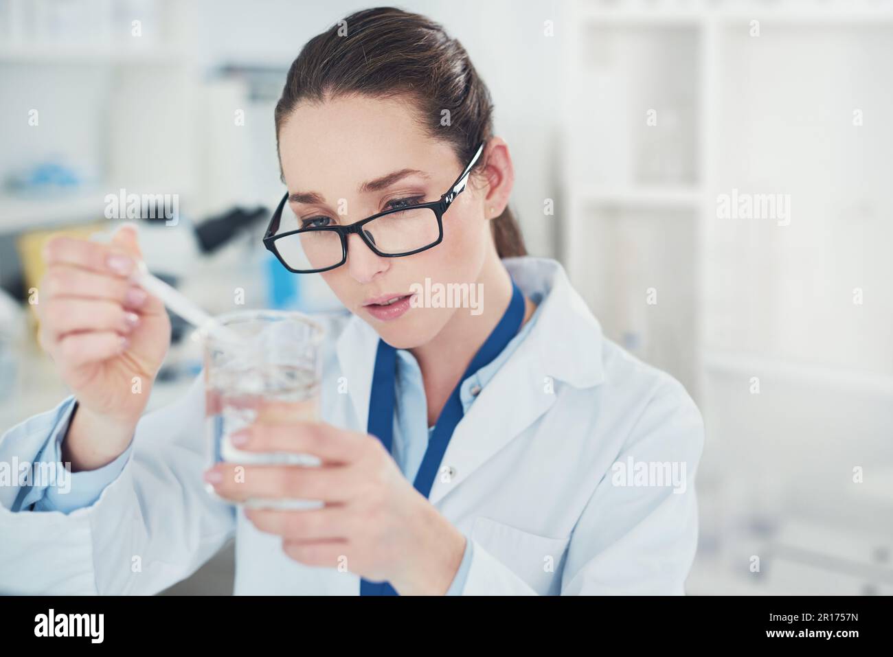 Whats this we have here. a focused young female scientist mixing ...