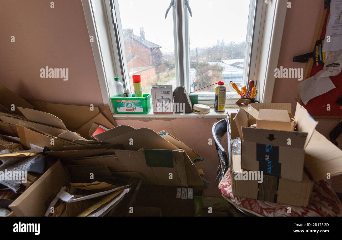 Heaps of cardboard packaging in a highly disorganised home workspace ...