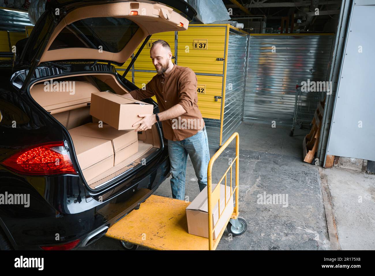 Grown man loading boxes into the trunk Stock Photo - Alamy