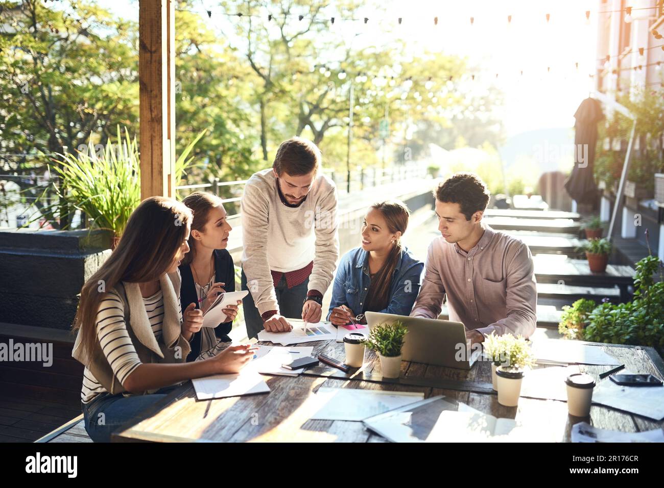 Moving their business meeting outside. a group of colleagues having a ...