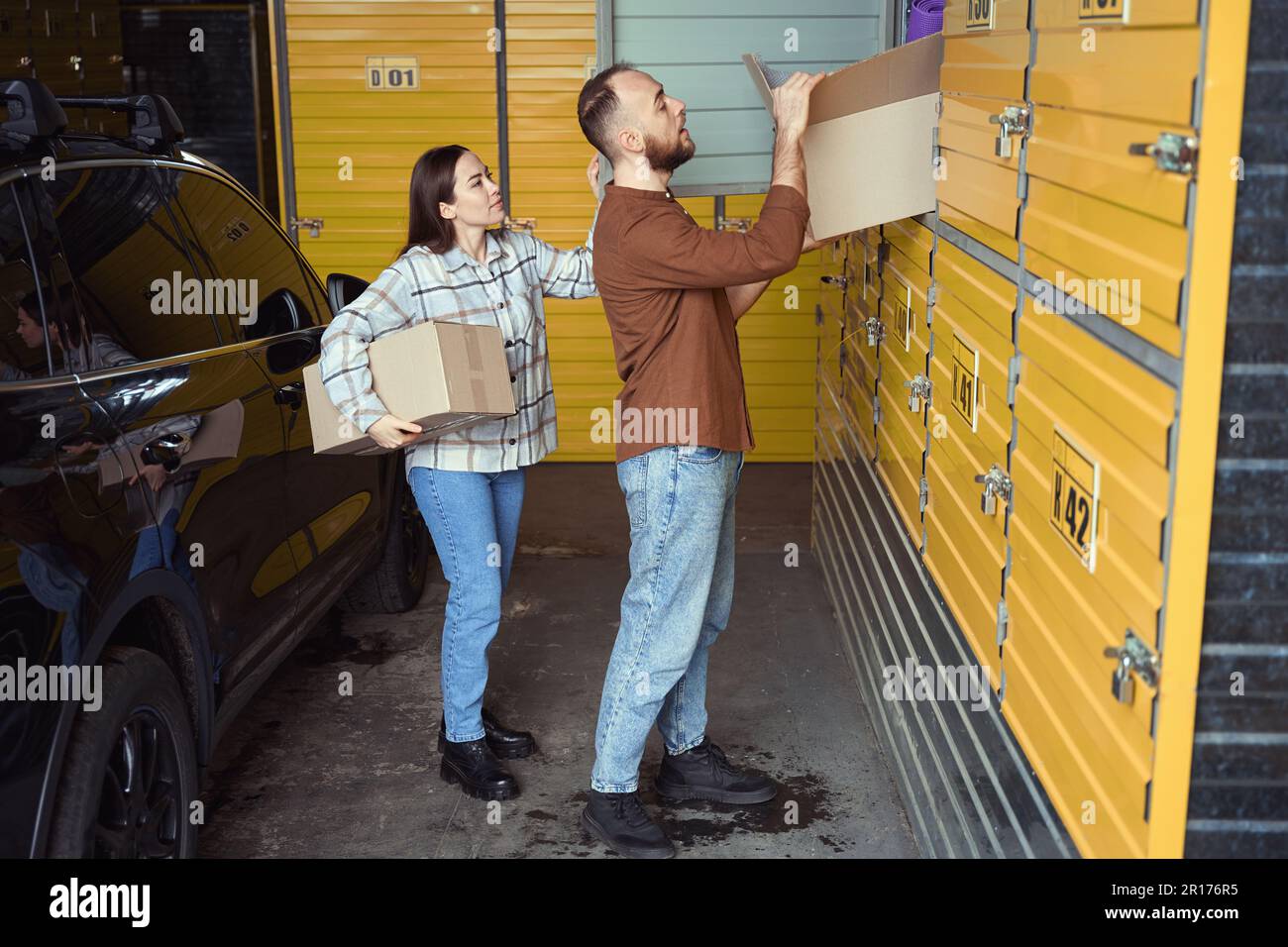 Young man and woman storing goods in a warehouse Stock Photo - Alamy