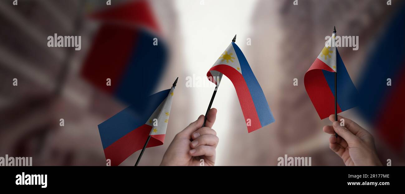 A group of people holding small flags of the Philippines in their hands ...