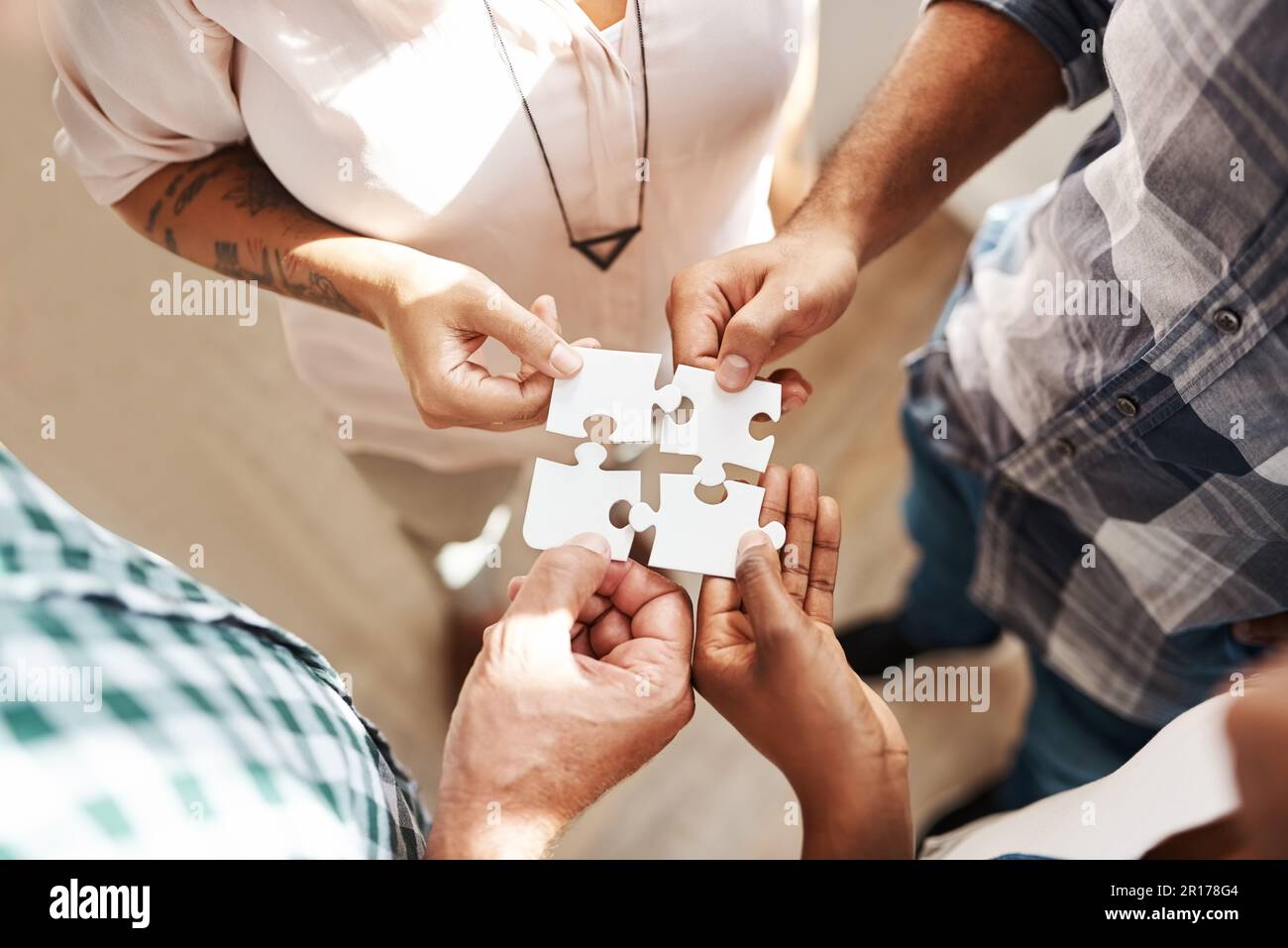 The solution is always teamwork. a group of creatives connecting pieces ...