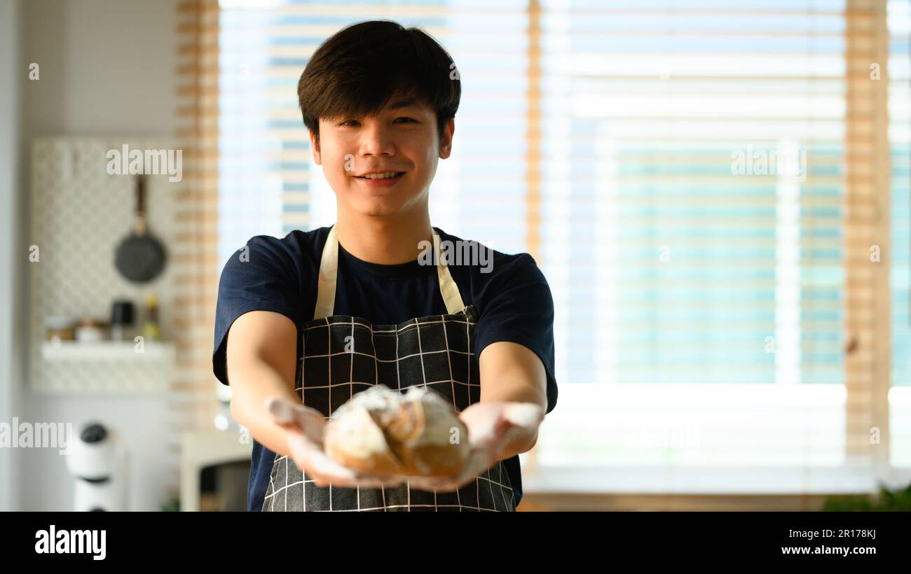 Portrait of male baker hands holding fresh sourdough bread. Healthy ...