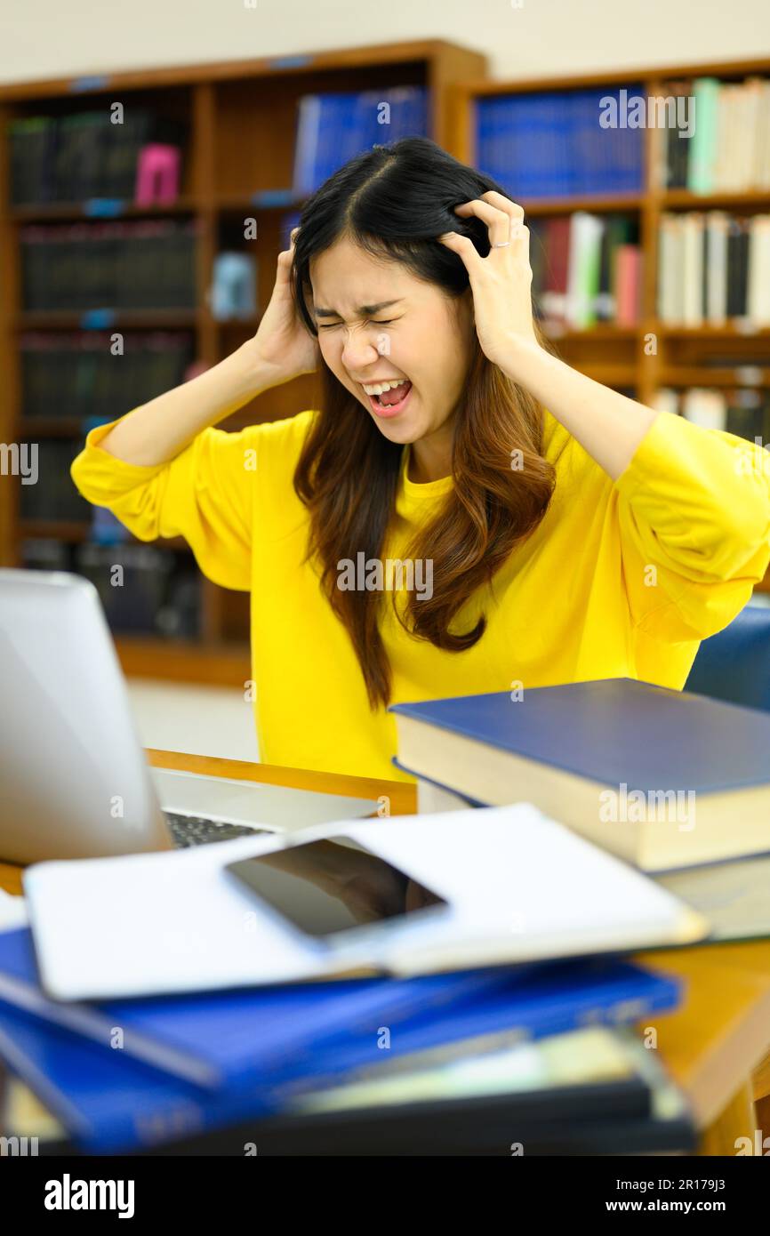 Stressed female student sitting in front of the laptop, having serious ...