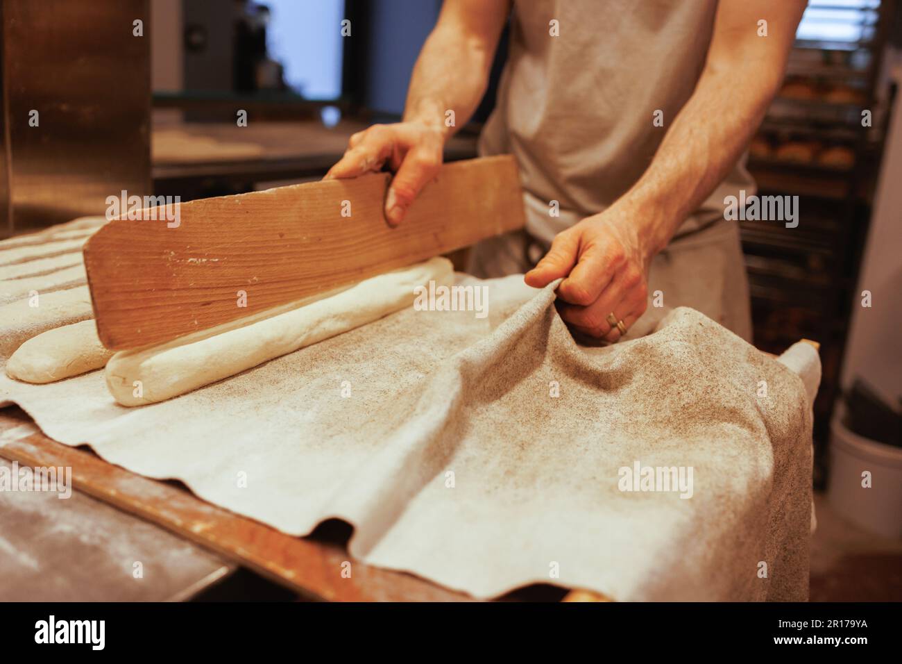 A cook using a rolling pin to slice freshly kneaded dough Stock Photo ...