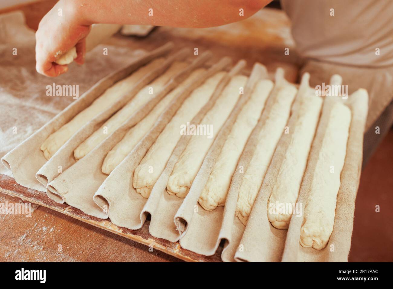 A baker working in the kitchen, preparing loaves of bread Stock Photo ...