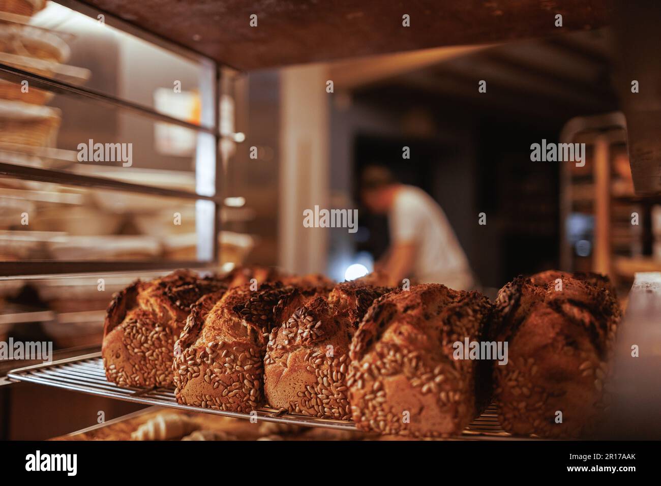A baker working in the kitchen, preparing loaves of bread Stock Photo ...