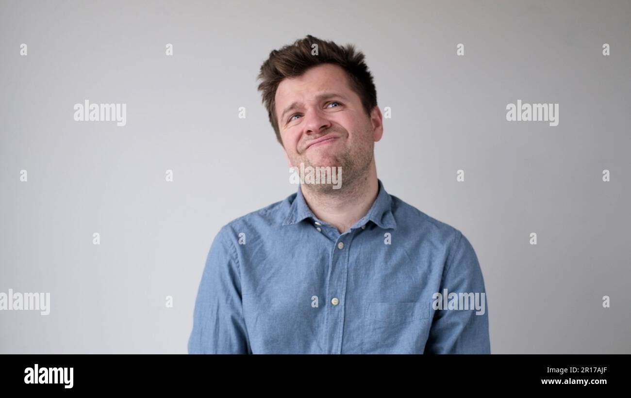 European young man is hesitating and unwilling to make decisions. He is ...