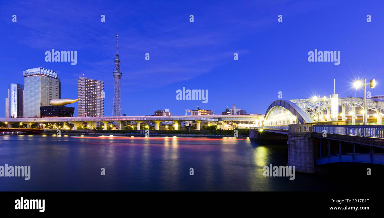 Tokyo Sky Tree, Komagata bridge, Sumida River and light trail of a ship ...