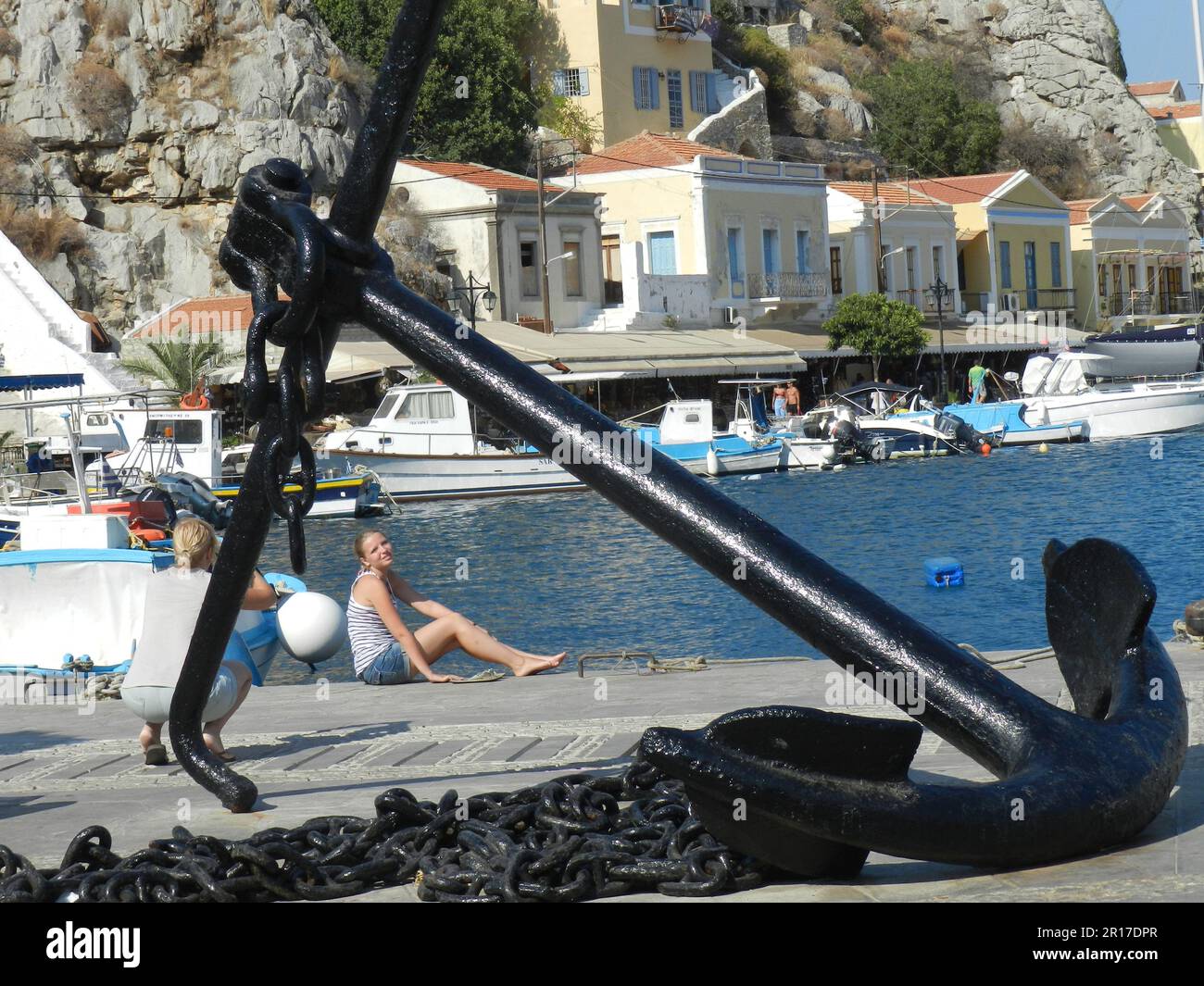 Greece, Island of Symi: an anchor on the jetty of Symi port, with ...