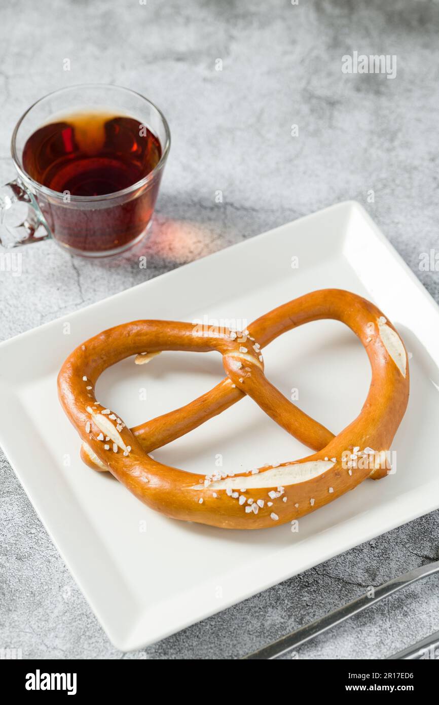 Pretzel in white porcelain plate on stone background Stock Photo - Alamy