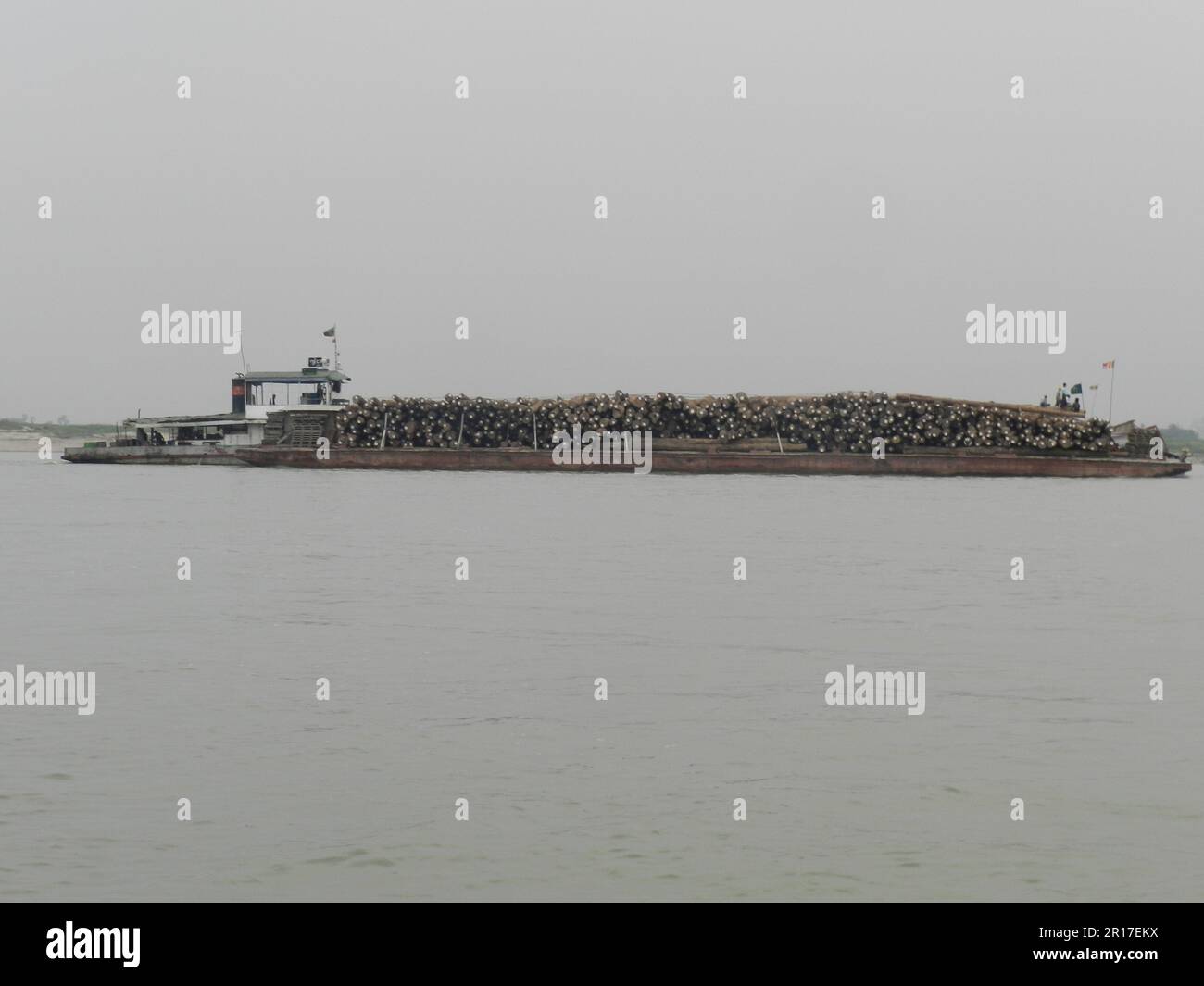 Myanmar, Mandalay: barge, laden with timber, on the Ayeyarwady River ...