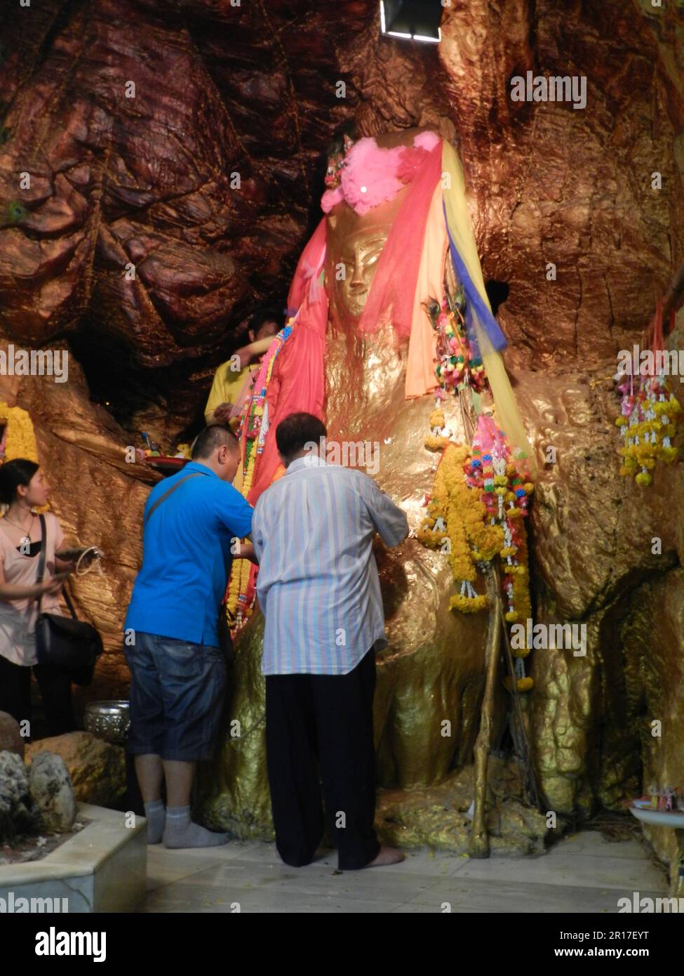 Thailand, Chonburi, Ko Si Chang Island: applying gold foil to a revered ...