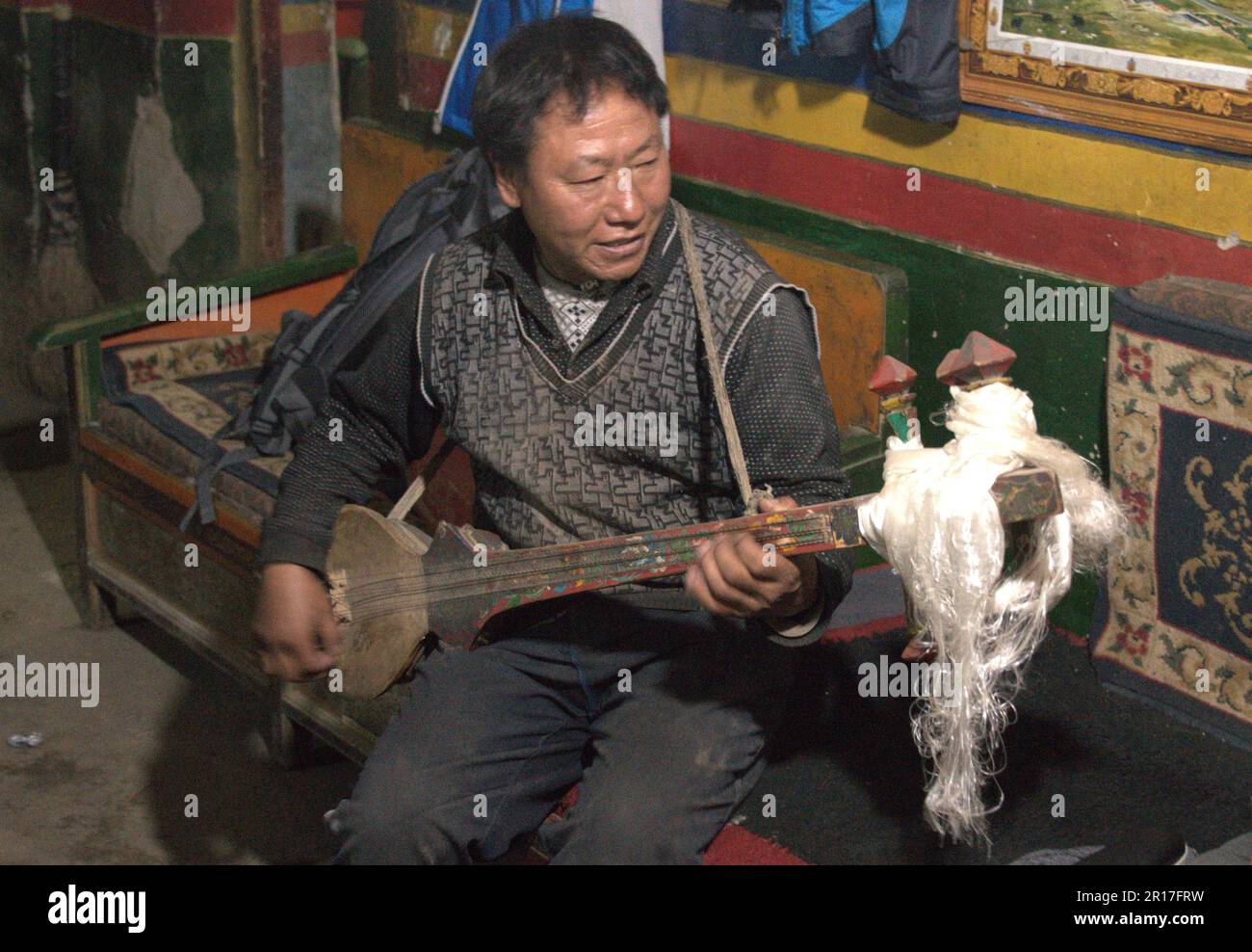 People's Republic of China, Tibet: mine host playing Tibetan 3-stringed ...