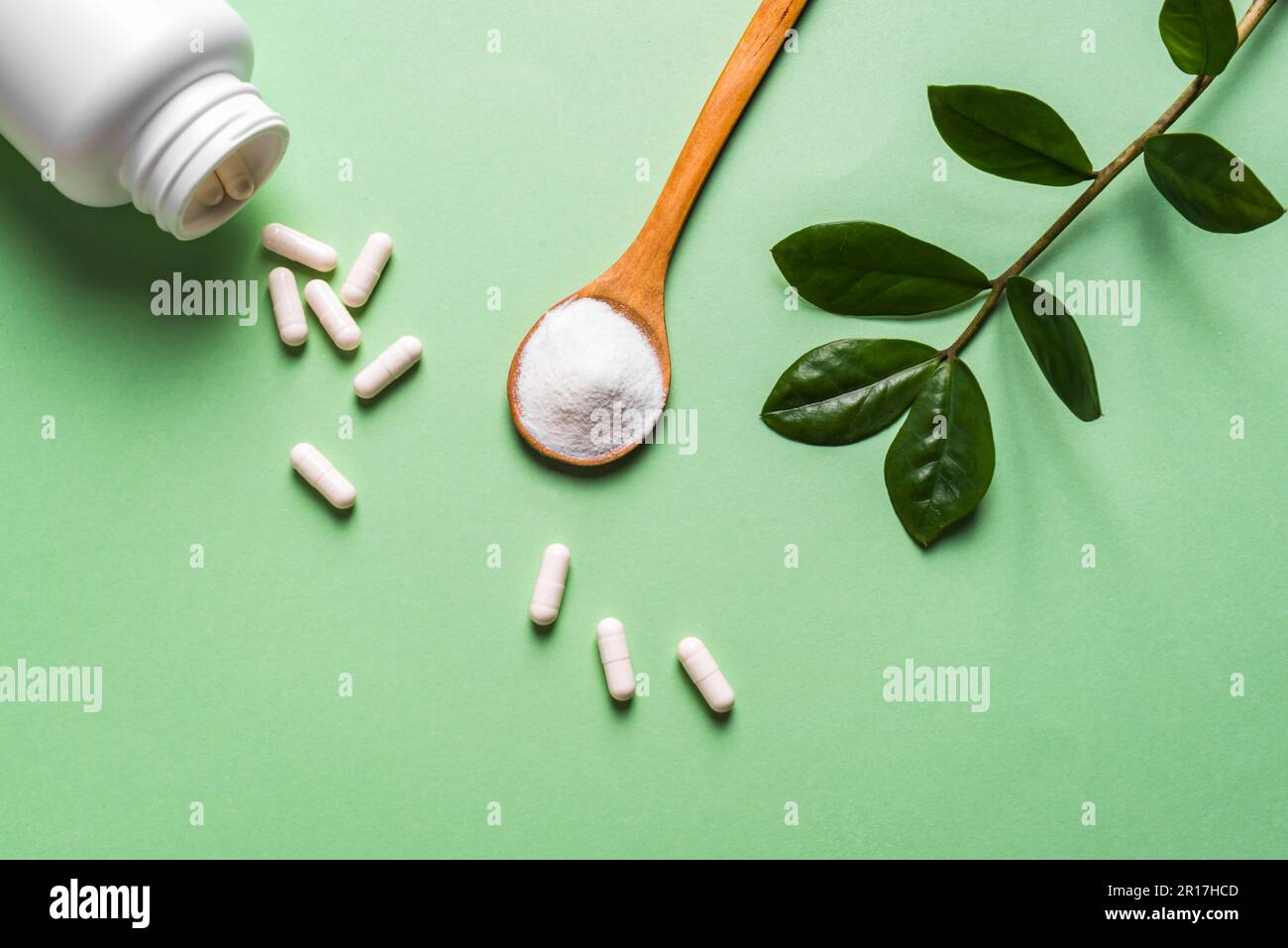 Collagen powder and capsules (pills) on green background. Vegan plant ...