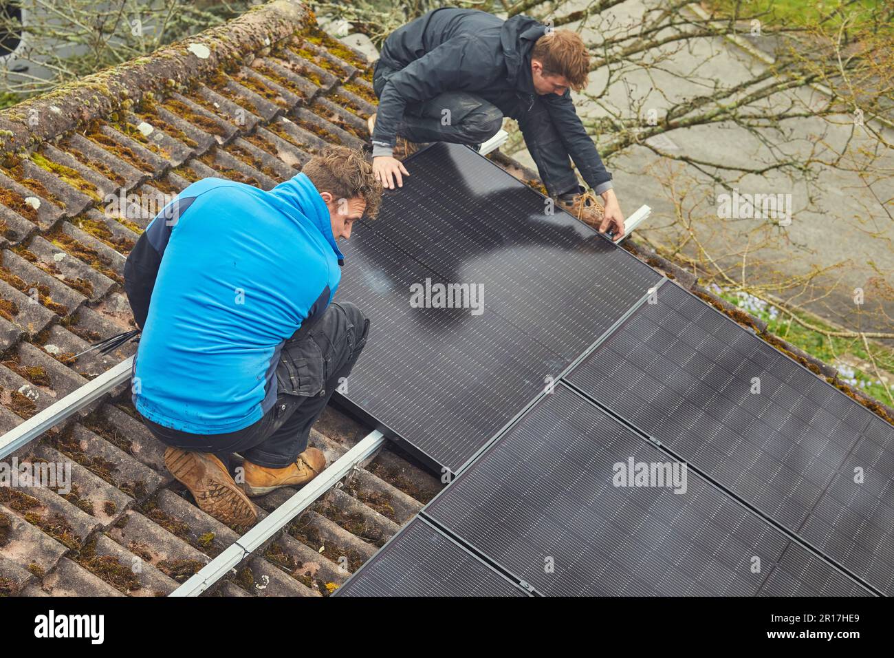 Photovoltaic solar panels being fitted to a residental roof in England ...