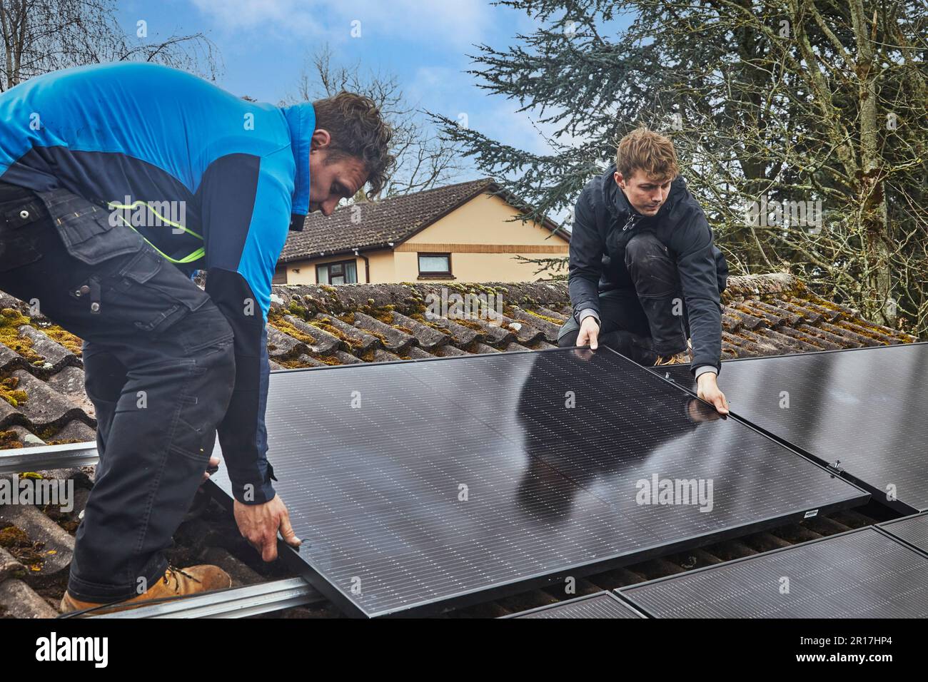 Photovoltaic solar panels being fitted to a residental roof in England ...