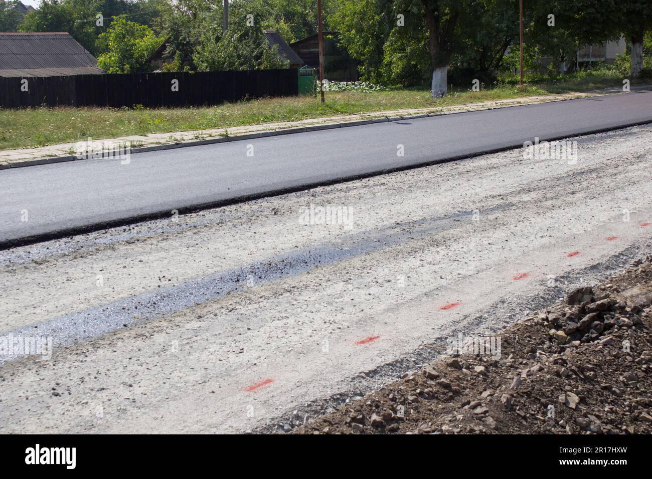 Layer of new laid asphalt, road construction, one part is covered with ...