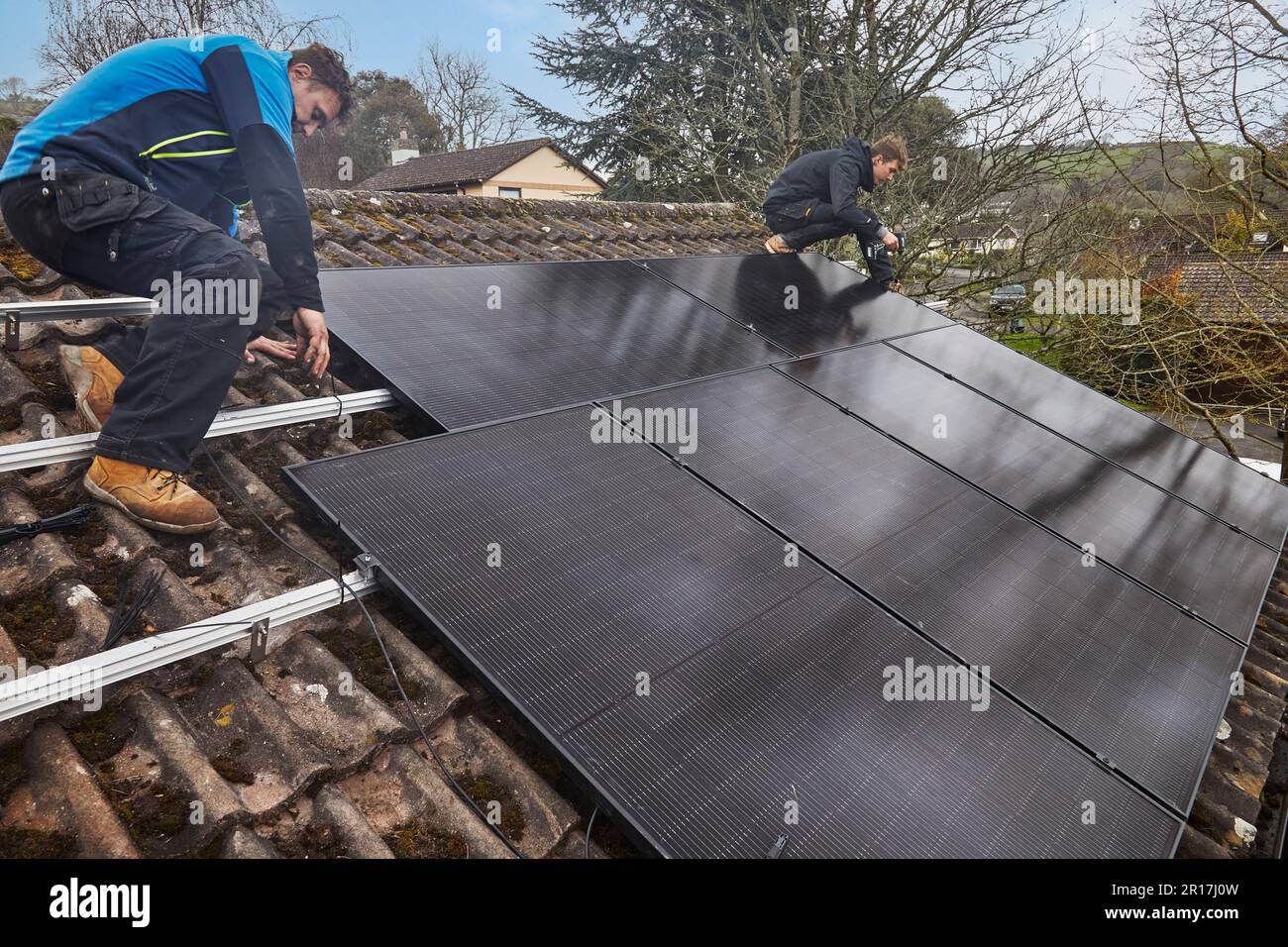 Photovoltaic solar panels being fitted to a residental roof in England ...