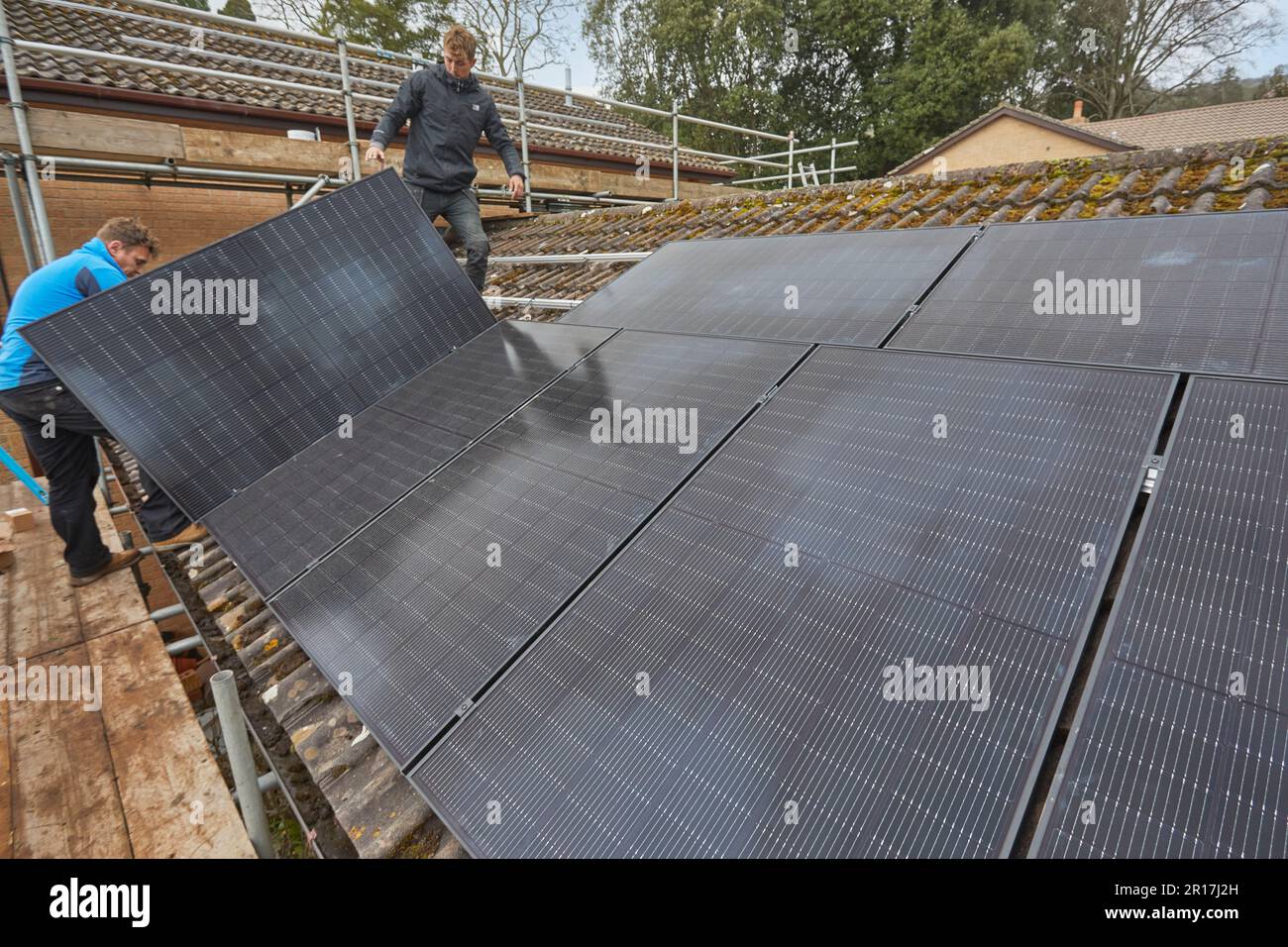 Photovoltaic solar panels being fitted to a residental roof in England ...