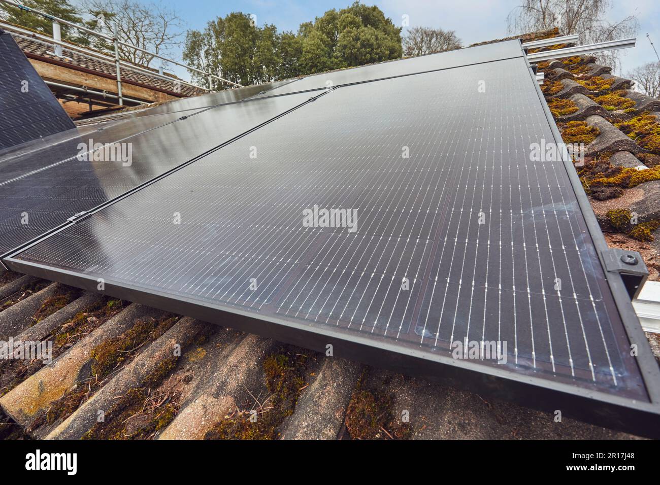 Photovoltaic solar panels being fitted to a residental roof in England ...