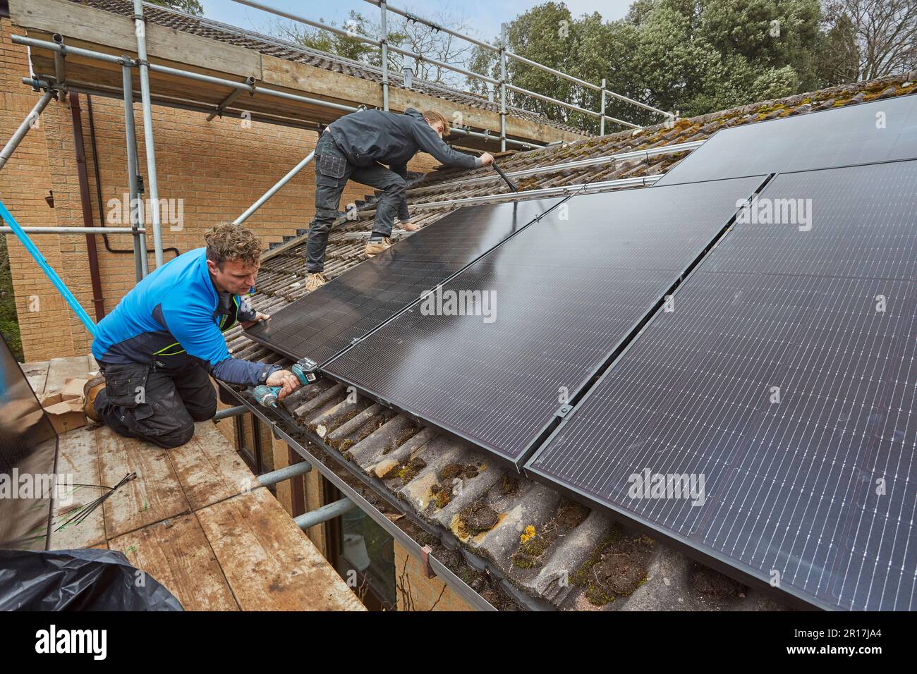 Photovoltaic solar panels being fitted to a residental roof in England ...