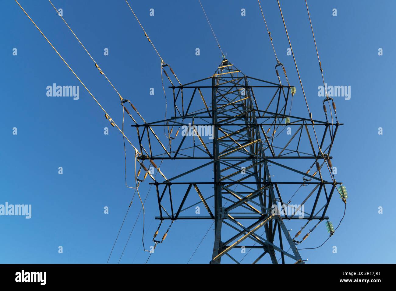 Steel mast of a high-voltage electric pole against the blue sky. Power ...