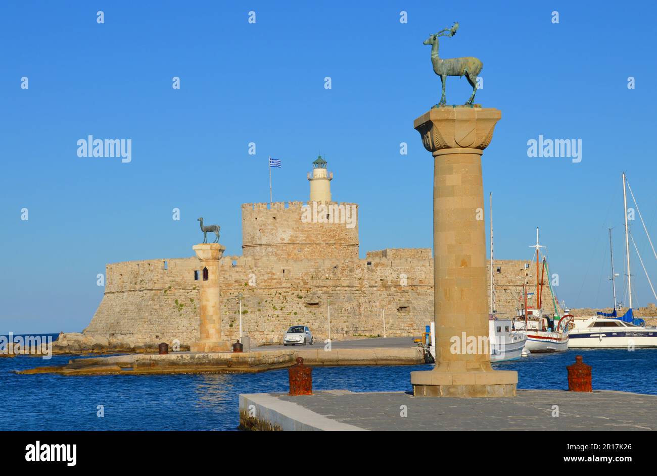 Greece, Island of Rhodes: entrance to Mandraki Harbour, with deer and ...