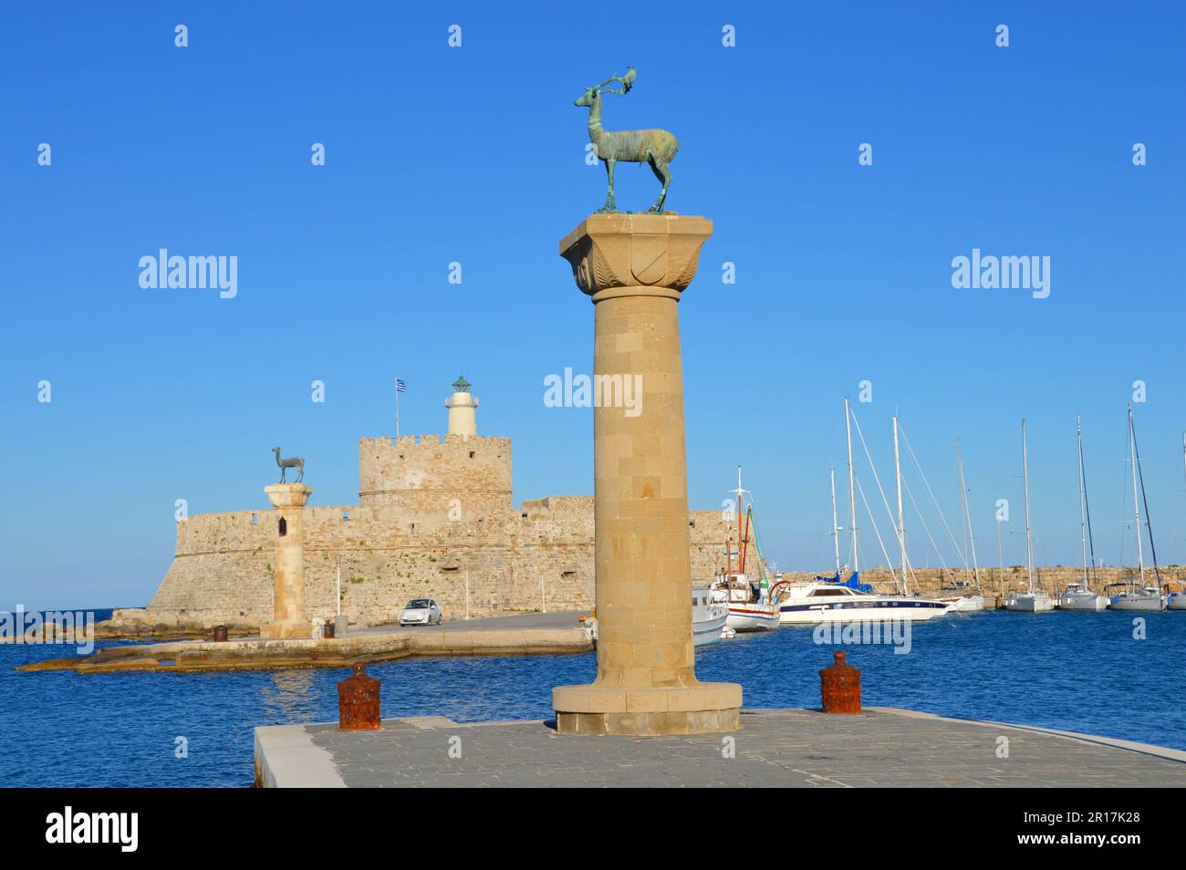 Greece, Island of Rhodes: entrance to Mandraki Harbour, with deer and ...