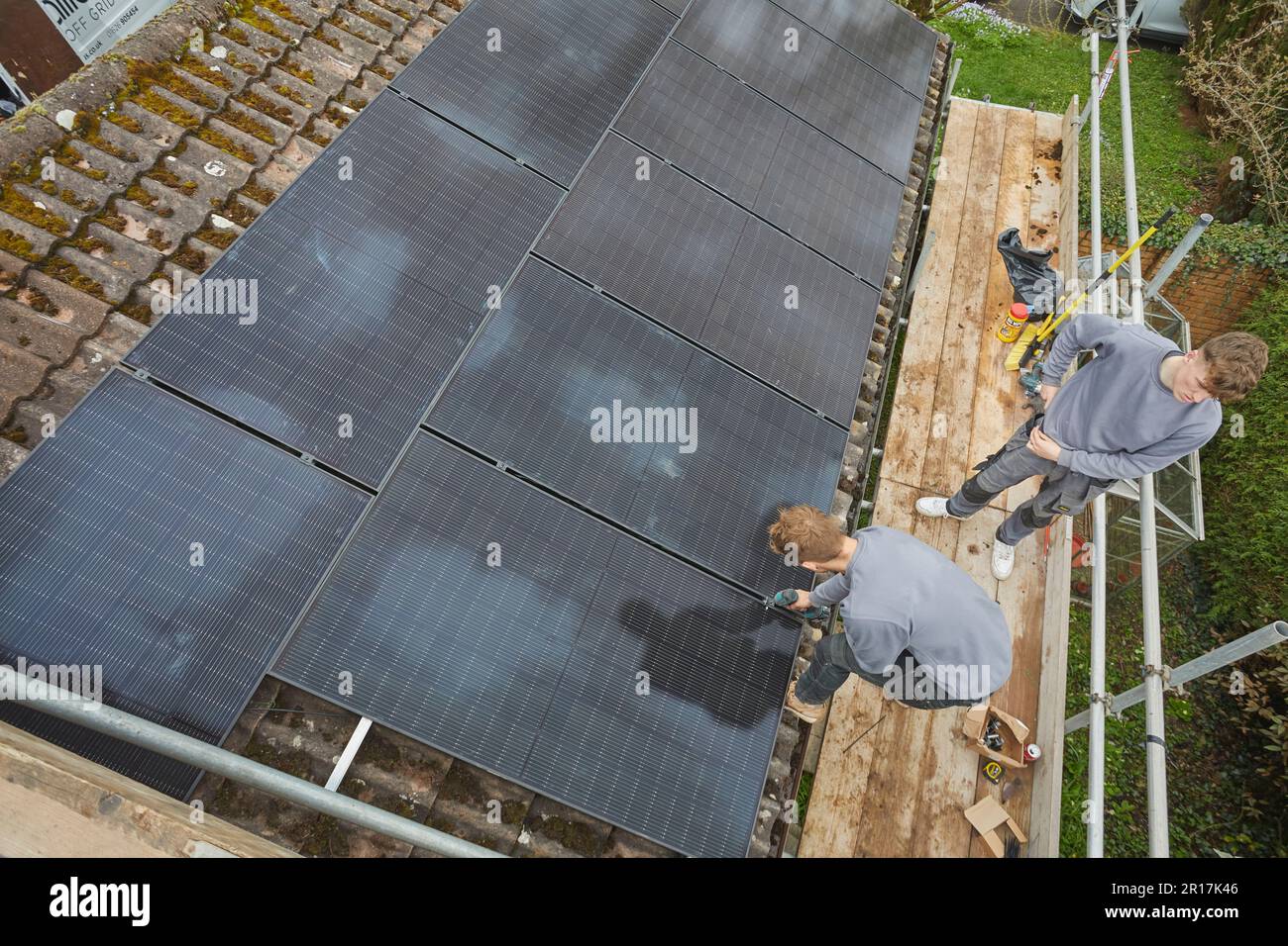 Photovoltaic solar panels being fitted to a residental roof in England ...