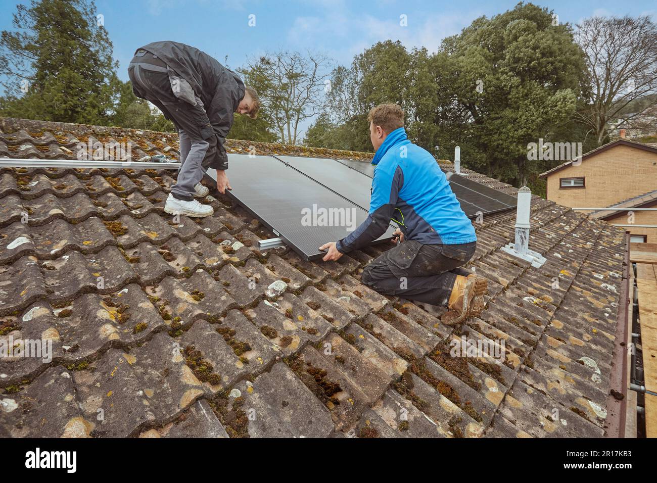 Photovoltaic solar panels being fitted to a residental roof in England ...