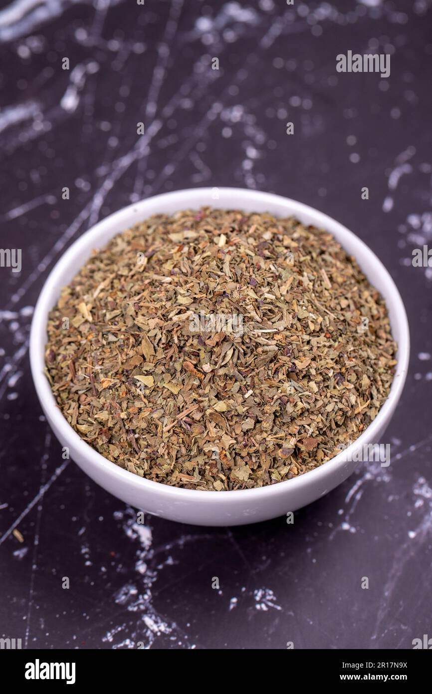 Dried crushed basil on dark background. Dried ground basil powder ...