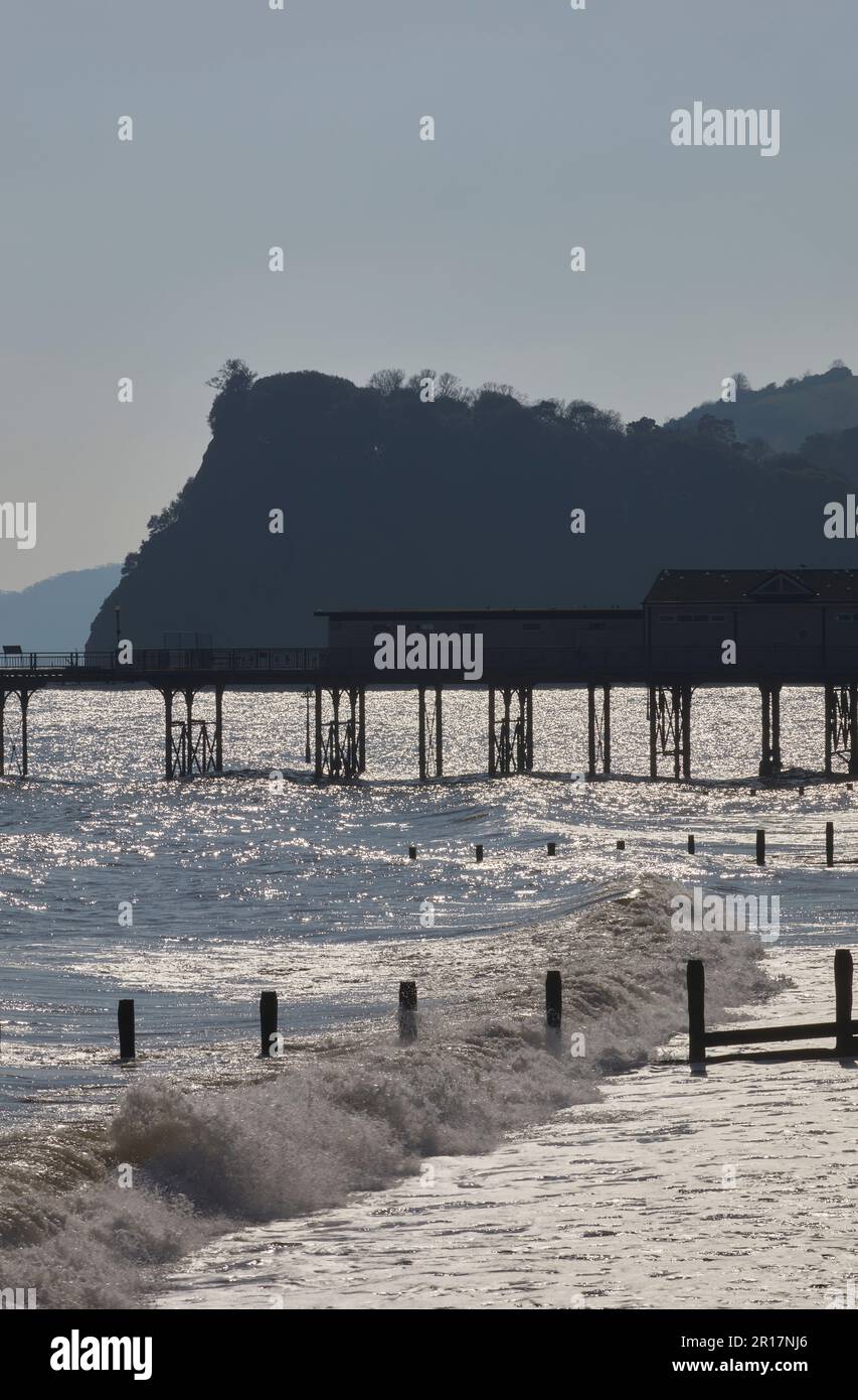 A silhouette view of the beach, pier and Ness headland, at Teignmouth ...