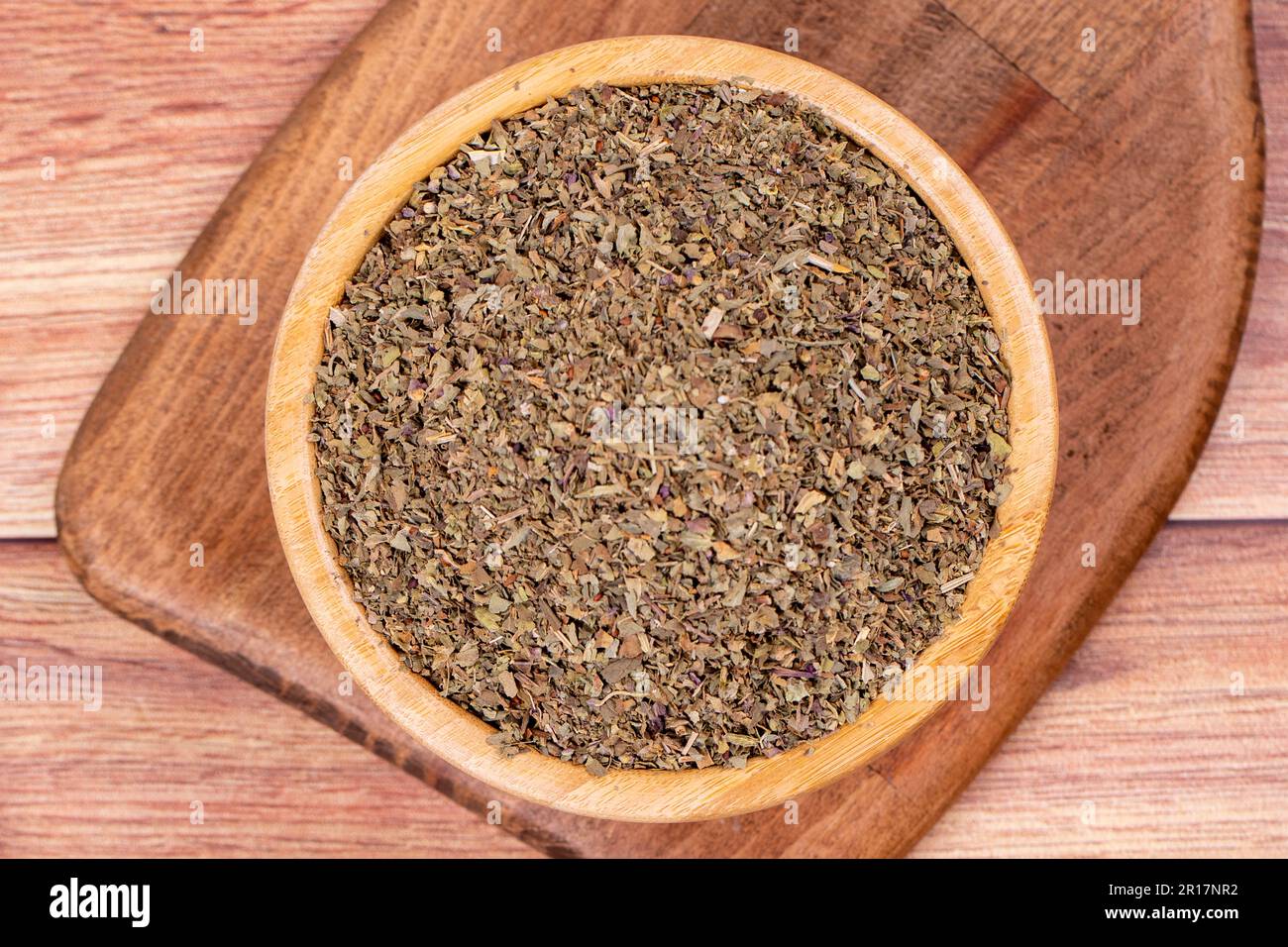 Dried crushed basil on wooden background. Dried ground basil powder ...