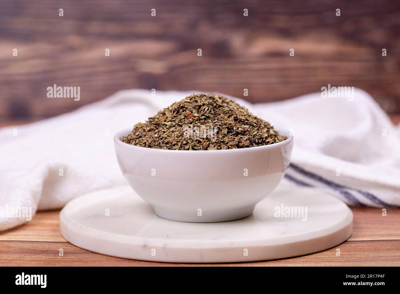Dried crushed basil on wooden background. Dried ground basil powder ...
