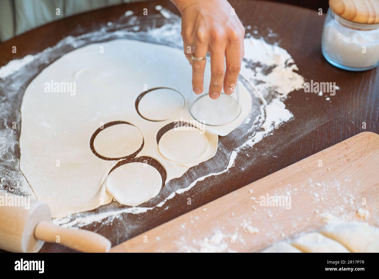 Woman's hands cutting out circles in dough by glass Stock Photo - Alamy