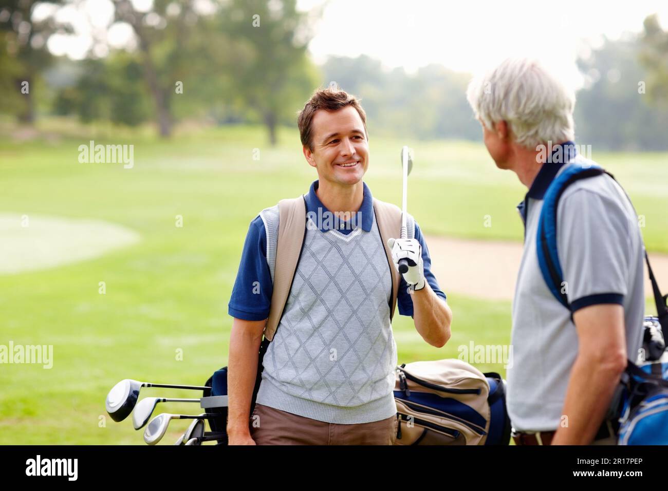 Father and son on golf course. Father and son having a friendly ...
