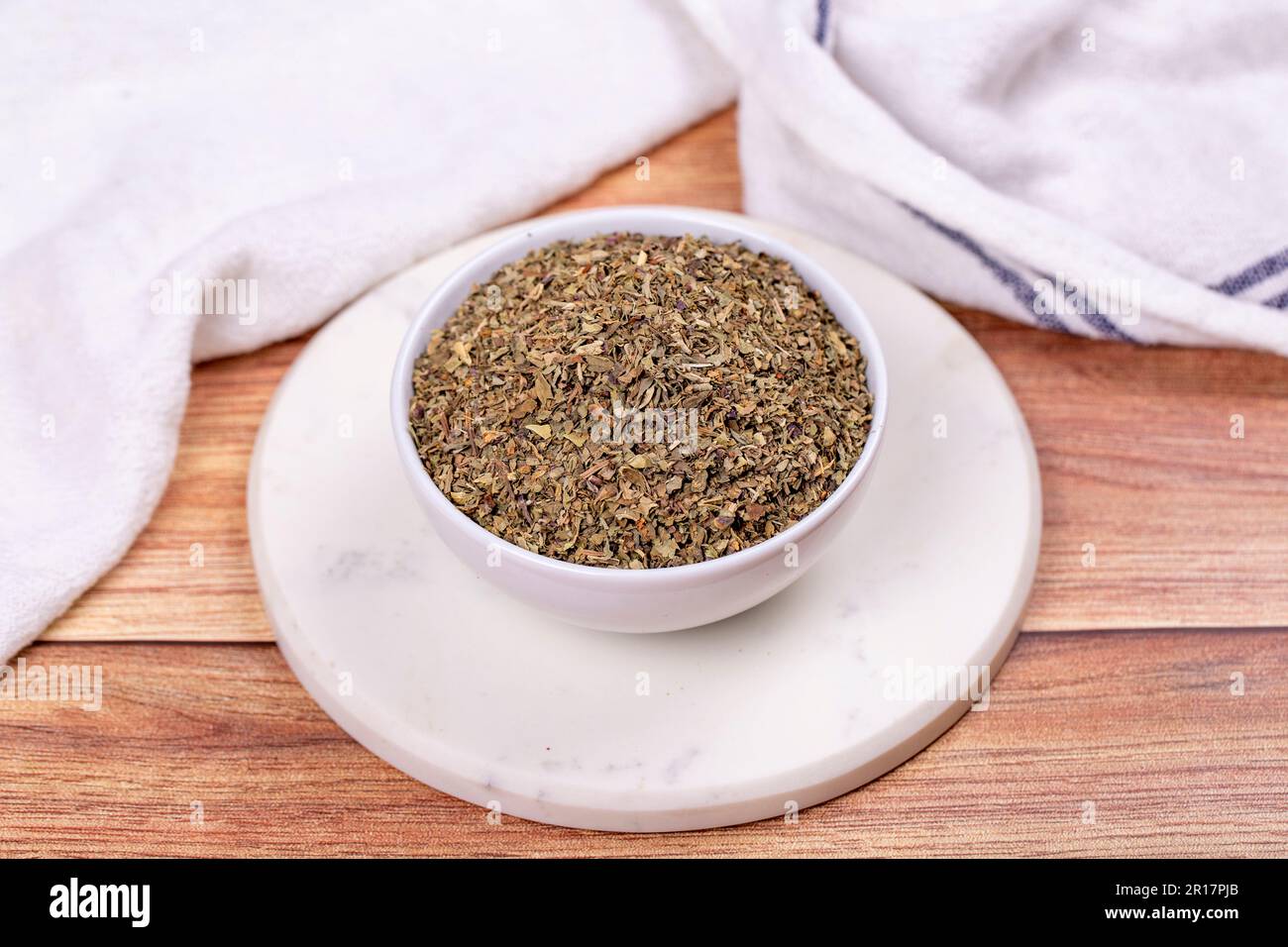 Dried crushed basil on wooden background. Dried ground basil powder ...