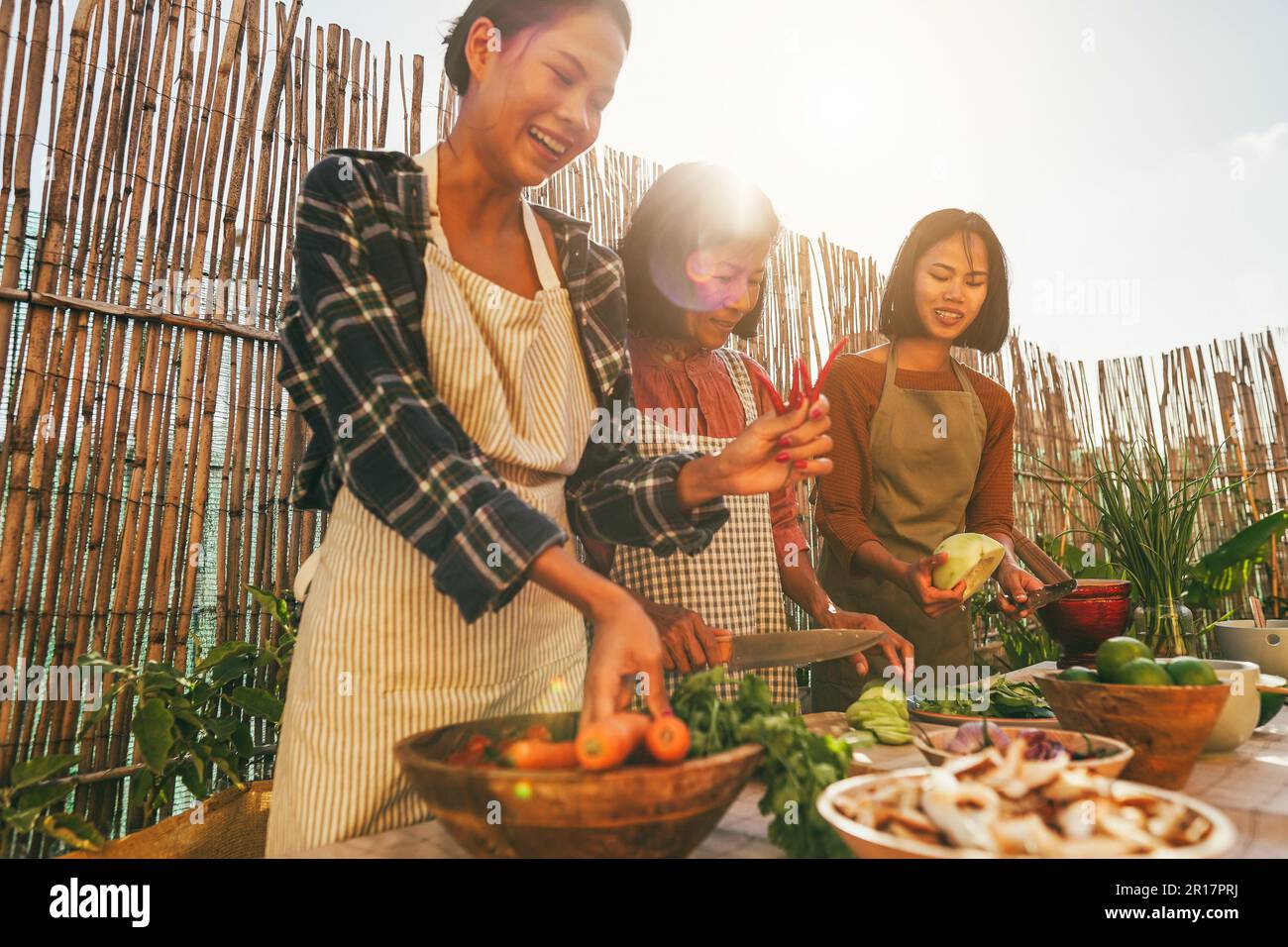 Asian family cooking thai dinner together while preparing papaya salad ...