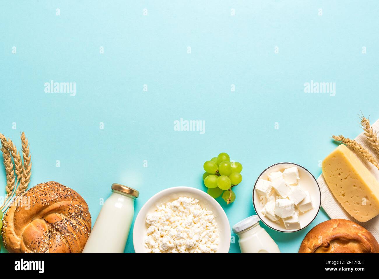 Happy Shavuot - Religious Jewish holiday concept with dairy products, cheese, traditional bread ...