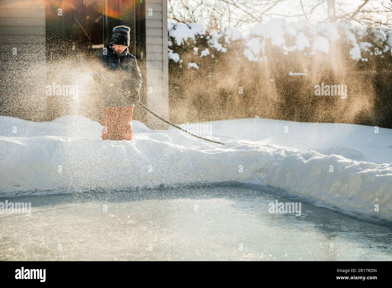Helpful 8 years old boy watering the ice rink Stock Photo - Alamy